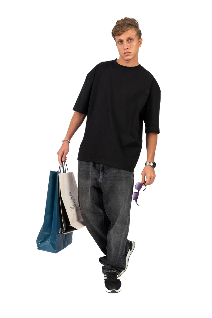 Egyptian male model posing with a shopping bag | Jini Stock
