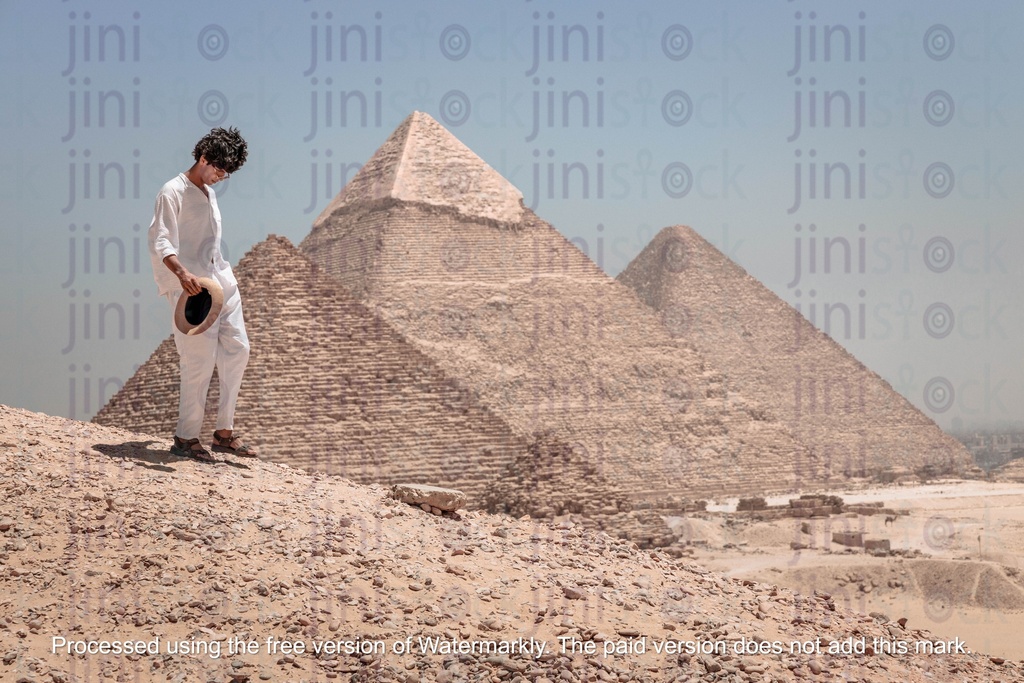 young man standing infront of the pyramids | Jini Stock