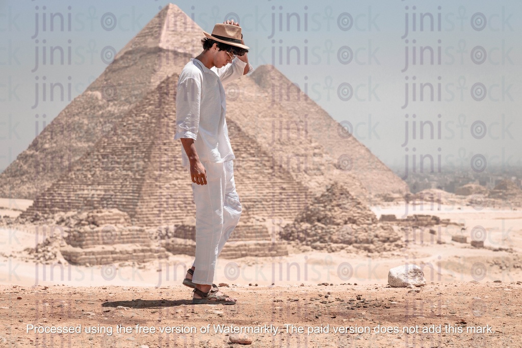 tourist wearing hat standing infront of the pyramids | Jini Stock