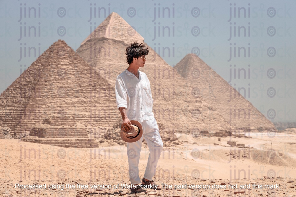 man standing with three pyraminds giza are in thebackground | Jini Stock