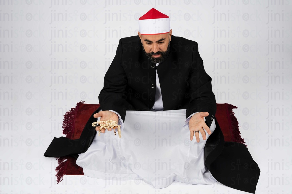 Sheikh sitting down giving a lesson | Jini Stock