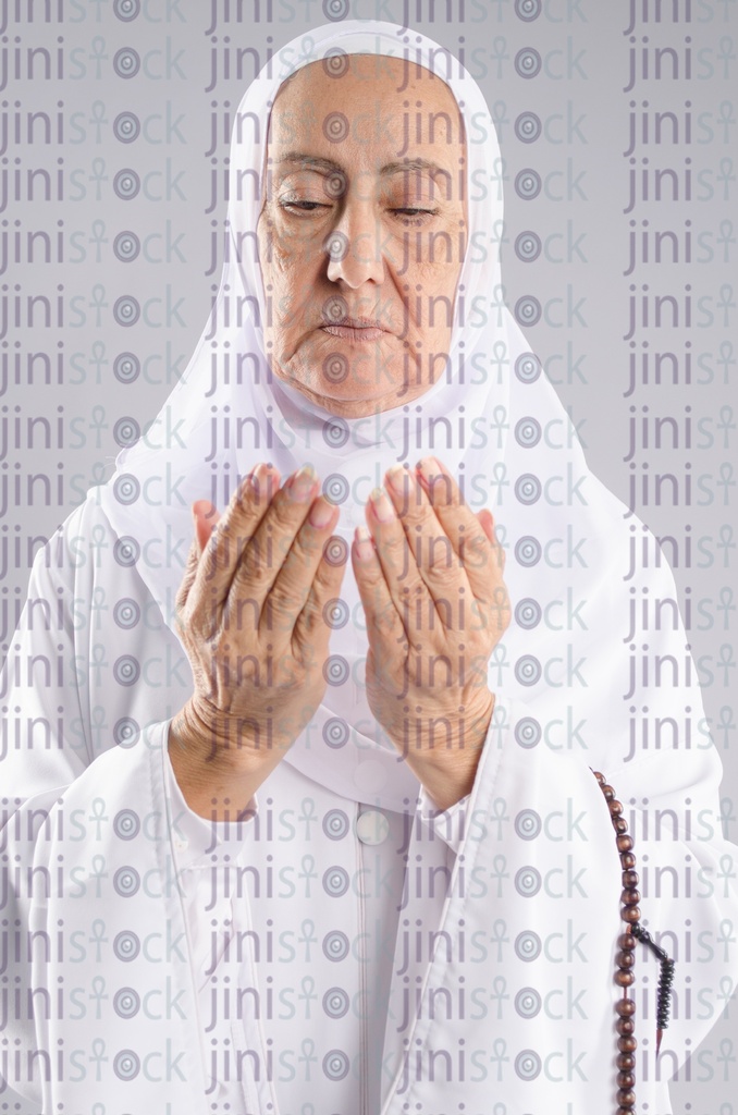 Old Egyptian woman praying | Jini Stock