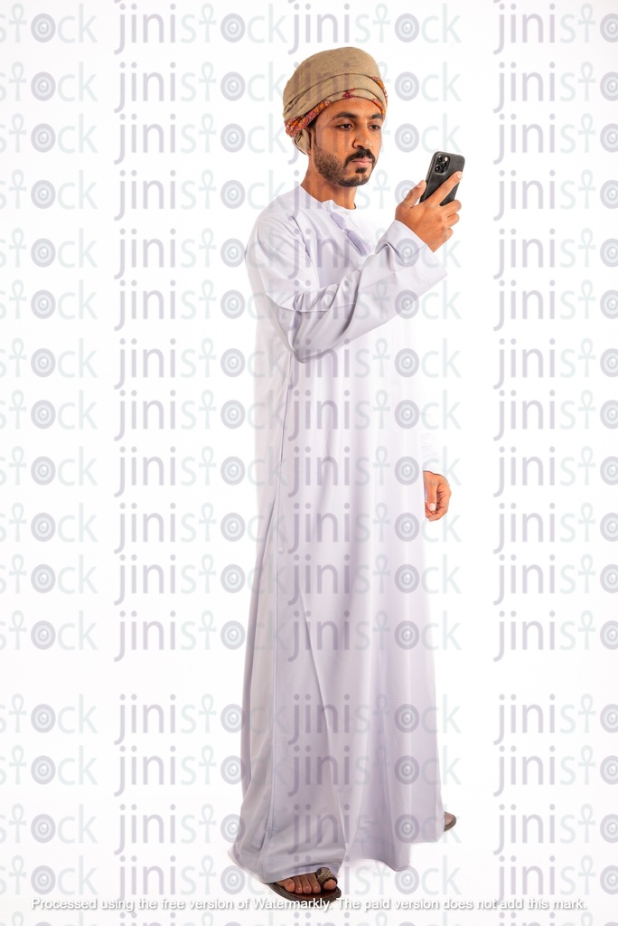 Omani arab khaliji man from gulf checking his phone | Jini Stock