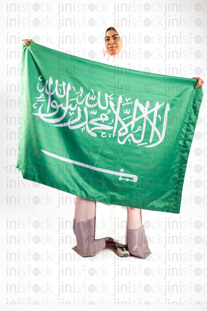 khaliji arab saudi woman from gulf carrying KSA flag | Jini Stock