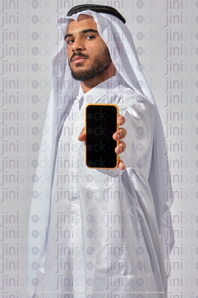 khaliji man from Qatar gulf Saudi holding a mobile phone | Jini Stock