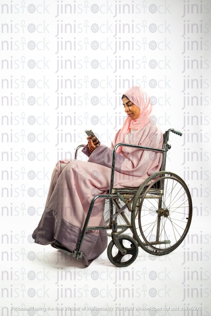 saudi khaliji woman on a wheelchair and working checking her mobile ...