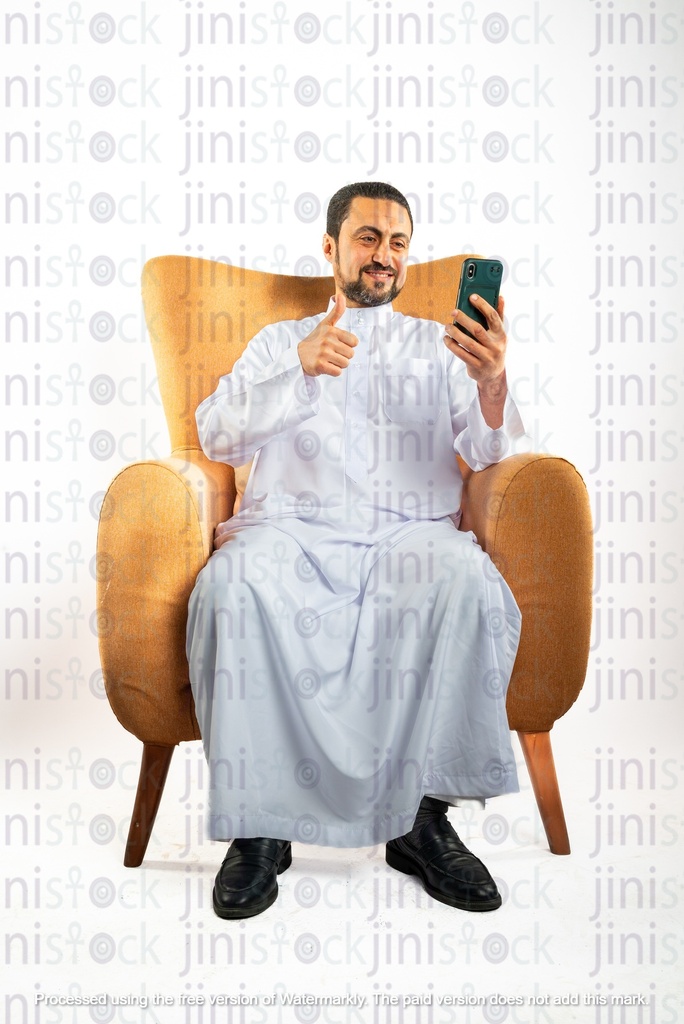 saudi khaliji man from gulf sitting on a chair holding mobile phone and ...